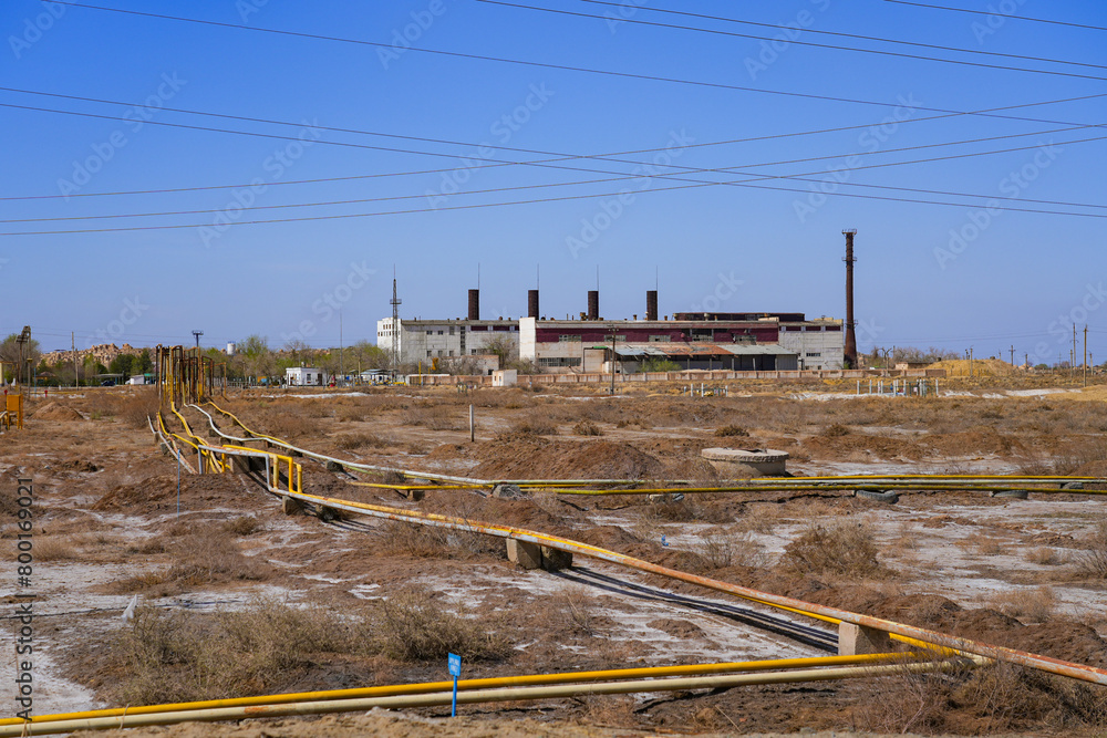 Soviet factory surrounded with pipes and gas conduits in the desert ...