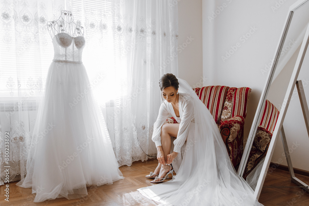 A bride is getting ready for her wedding, putting on her wedding dress ...