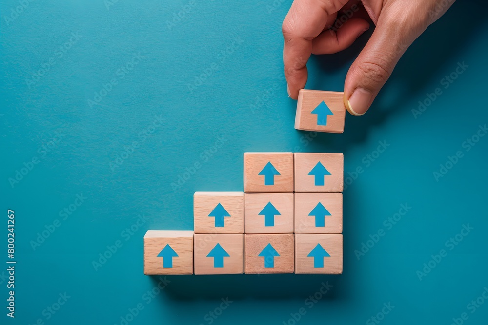 Hand holding block with upward arrow on blue background, creating ...