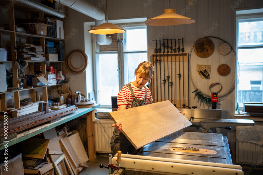 Female carpenter carefully working with table. Girl joiner woodworker ...