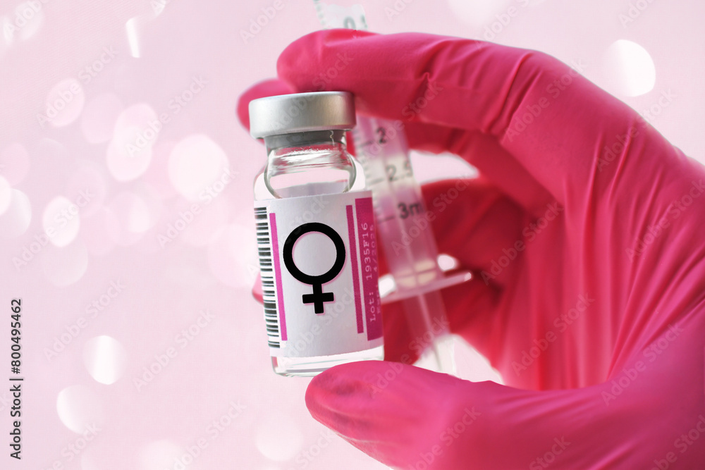 Pink gloved hand holding a vial with female symbol, hormones injections ...