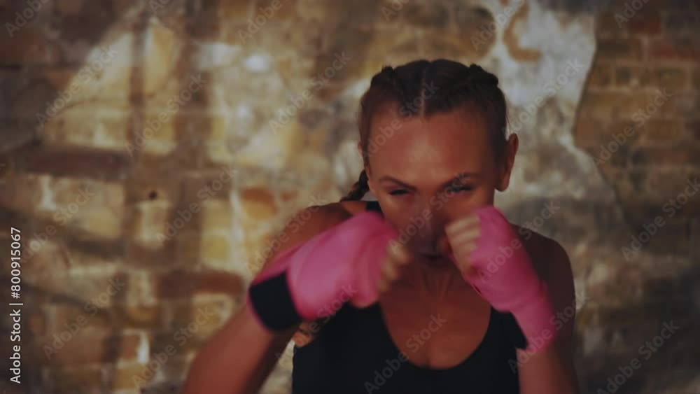 Athletic woman engages in shadow boxing, her stance sharp against the ...