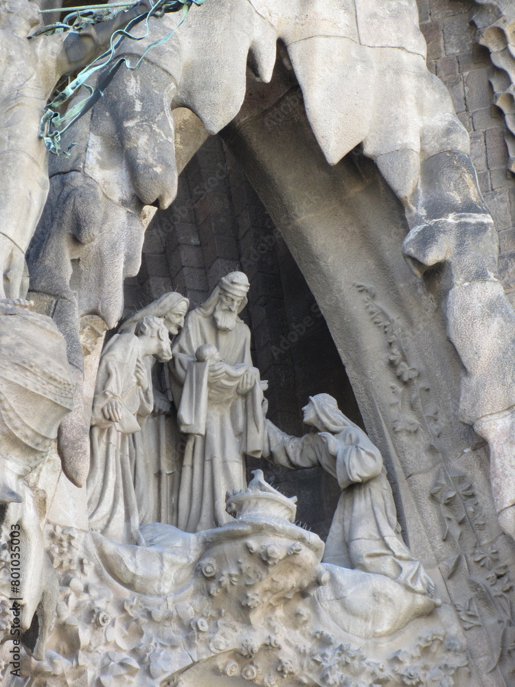 Statues with a biblical, religious scene, made of gray granite, seen at the entrance of the ...
