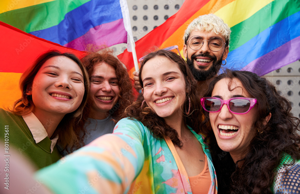 Cheerful selfie of a group of LGBTQIA people in a pride parade, looking ...