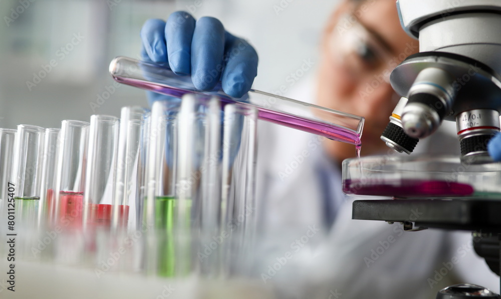 Female chemist holds test tube of glass in hand closeup overflows ...