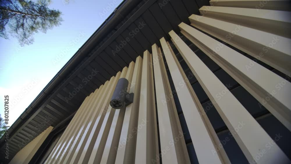 Modern surveillance IP camera placed on wall of residential wooden ...