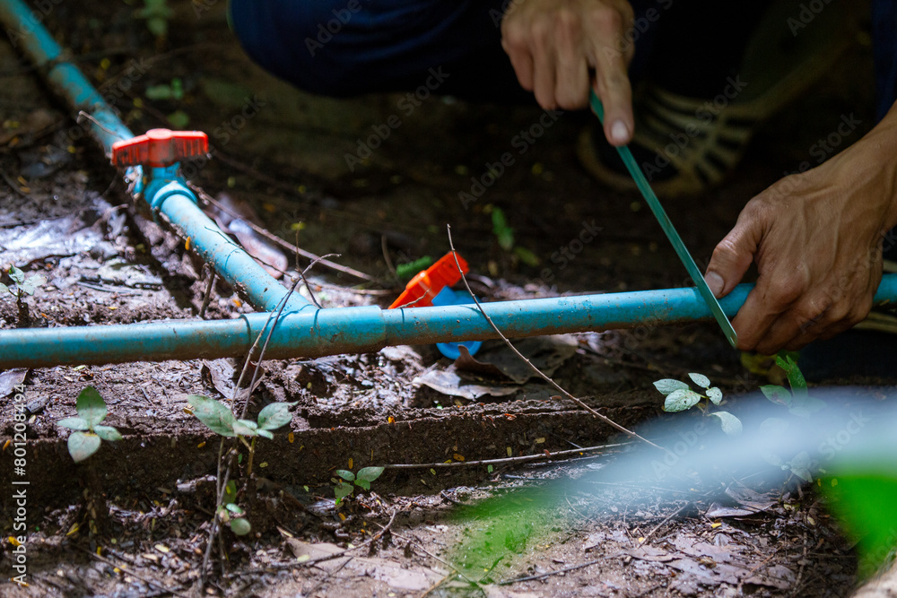 Selective focus blue PVC water pipe. Using a small saw to cut plastic ...