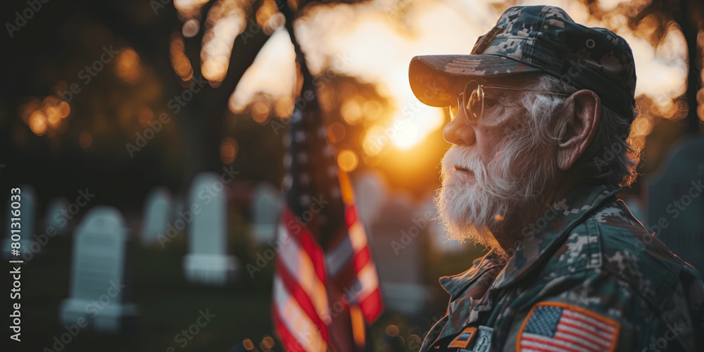Elderly veteran in military attire reflecting at a cemetery during ...