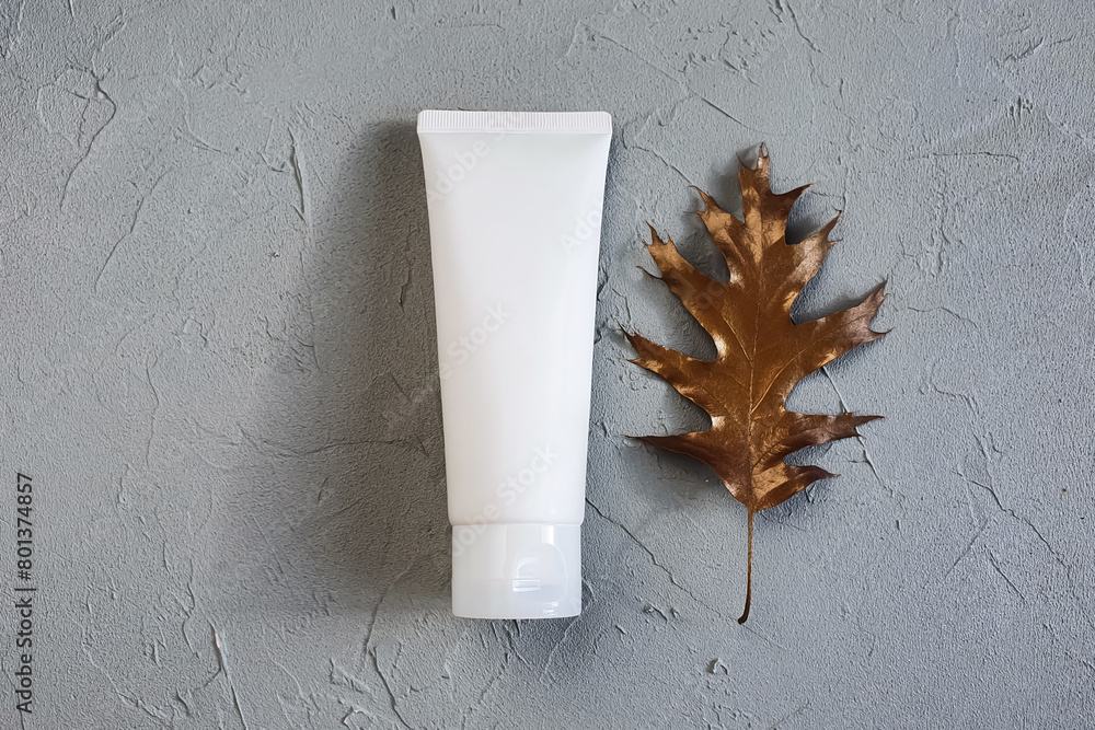 cosmetic tube, golden brown oak leaf on gray concrete texture ...