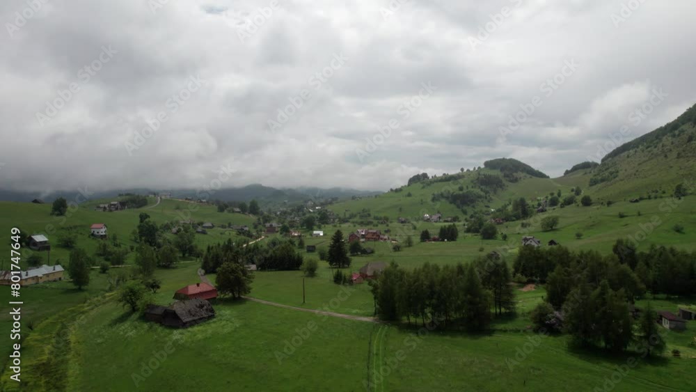 Sirnea village in romania with green hills and scattered houses, cloudy ...