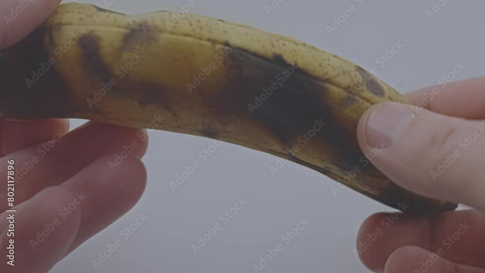 Person hand touches overripe banana over white table at home. Texture ...