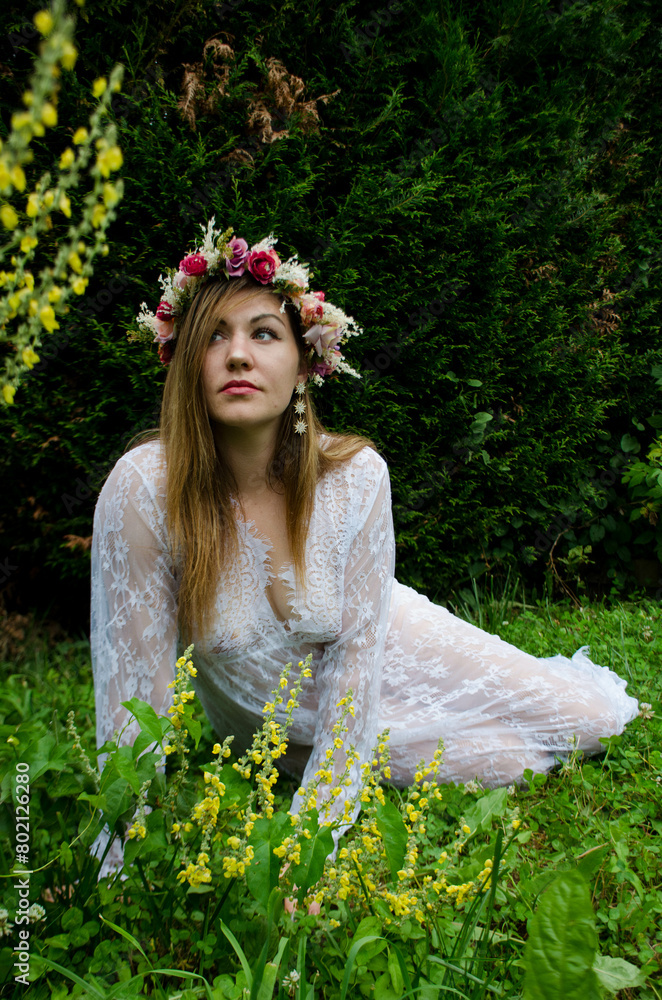 Femme blonde avec une couronne de fleur et une robe en dentelle blanche dans la nature Stock ...