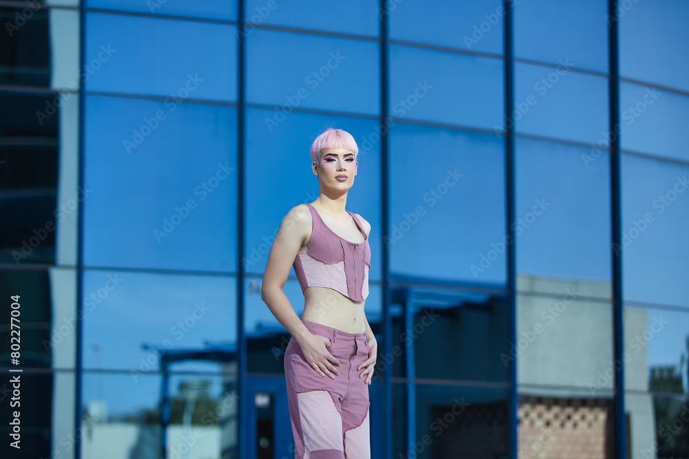 Young, attractive, gay man, heavily makeup, with pink hair, top and ...