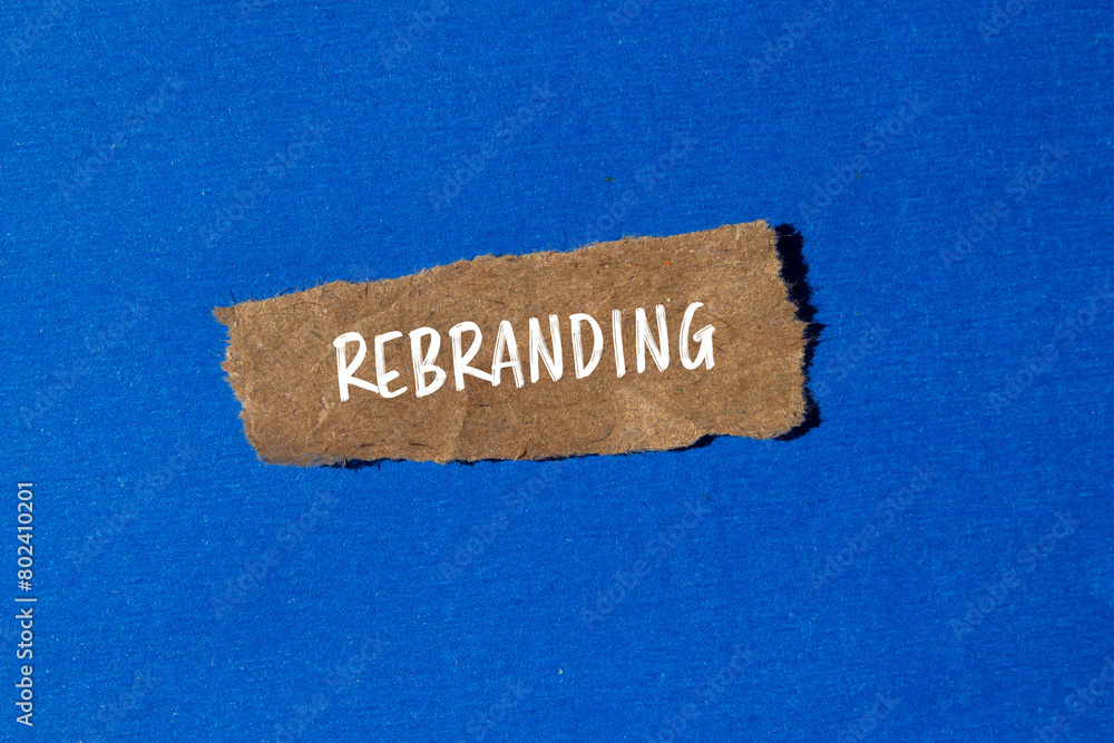 Rebranding word written on ripped paper piece with blue background ...