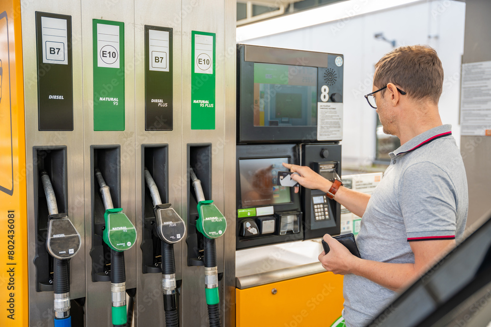 The man pays for fuel with a credit card on terminal of self-service ...