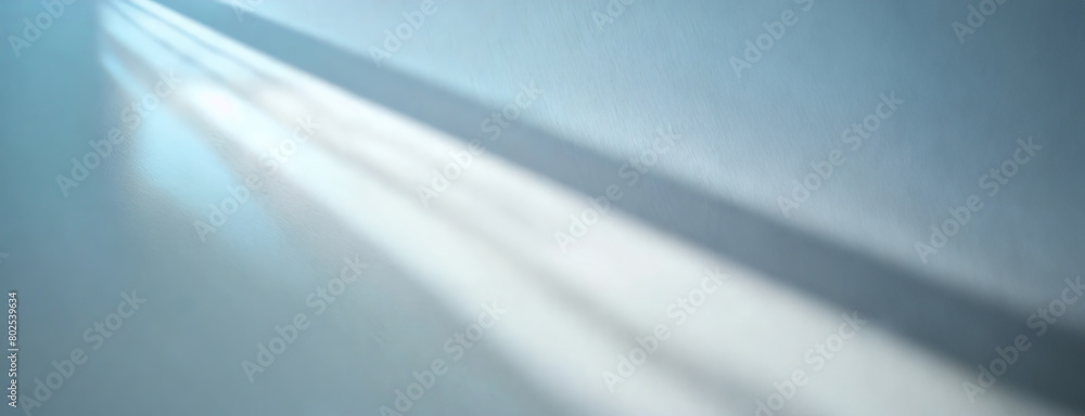 Sunlight casts sharp, elongated shadows on a plain wall, creating a ...