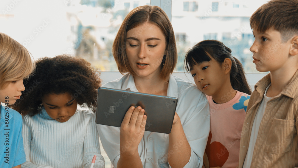 Smart teacher holding tablet while open online lesson to group of ...