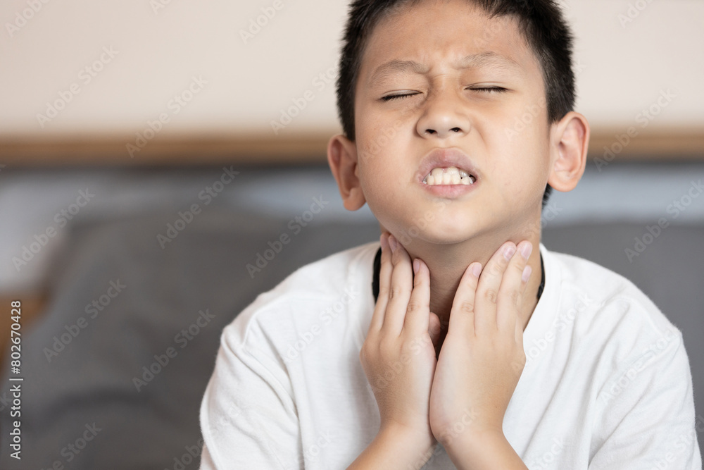 Asian child boy touching his neck,loss of the voice,hoarseness,voice is ...