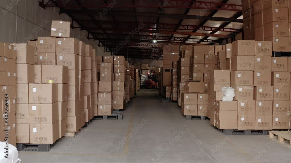 Storage facility filled with hundreds of boxes. A forklift is moving ...