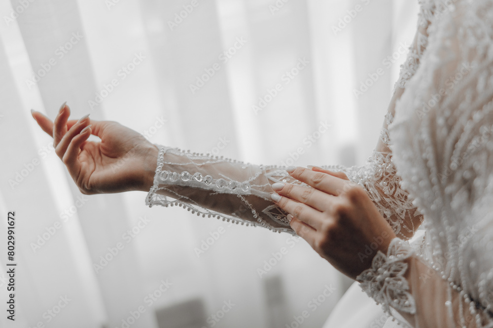 A woman is wearing a white dress and is holding her arm up to show off ...