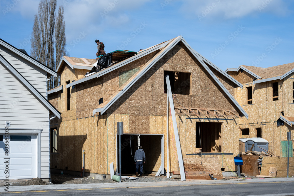 Workmen on a new residential community construction job site, house ...