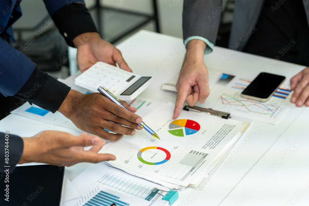 A group of people are working on a project, with one person pointing at ...