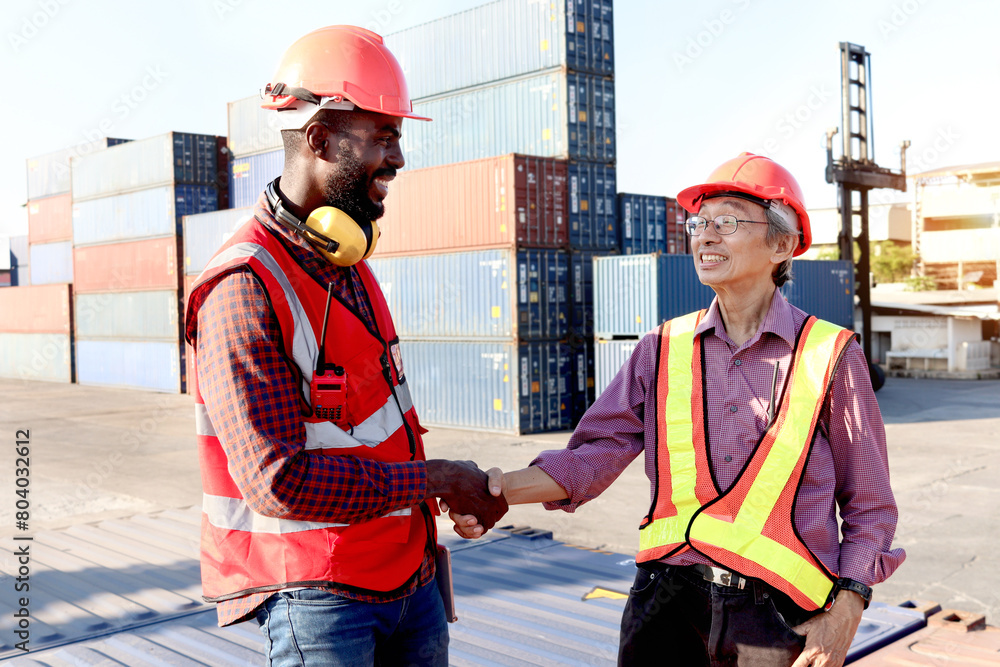 Two worker wear safety helmet and safety red vest shaking hands at ...