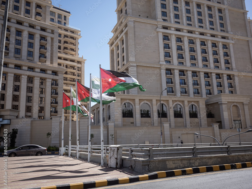 tall modern buildings and jordanian national flag poles at the circle ...
