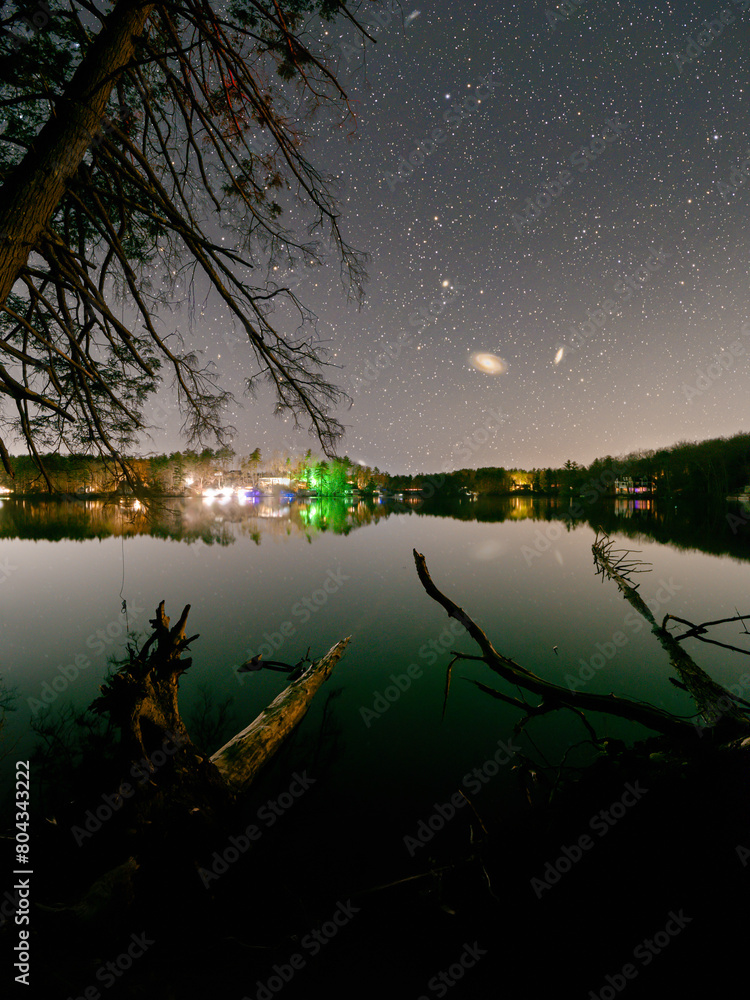 A composite photo showing a wide angle view of a small lake at night ...