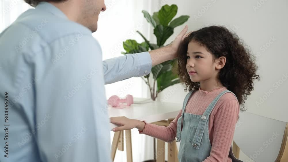 Back view of smart dad rub his daughter gently on her head and giving ...