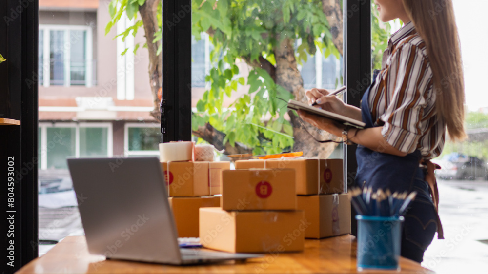SME business operator is inspecting and packing products into parcel ...