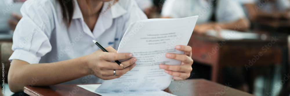 Students writing and reading exam answer sheets exercises in classroom ...