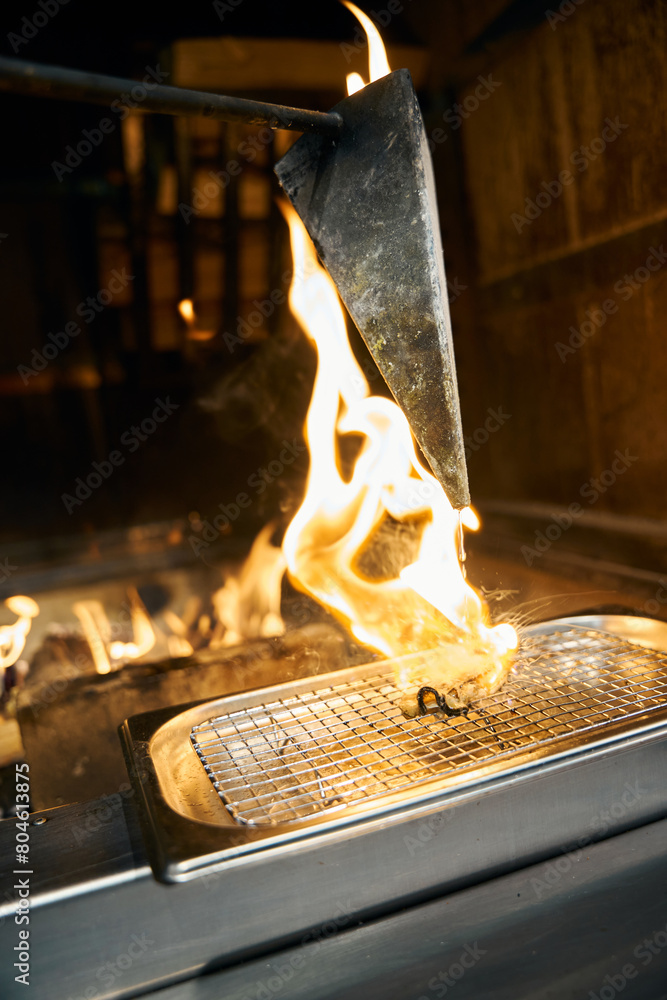 Flambe technique cooking of burning iron triangle pot frying oyster on ...