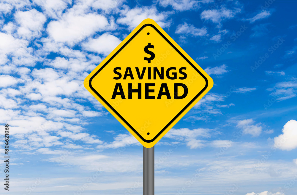 A 'Savings Ahead' sign. It features a dollar sign on a road sign ...