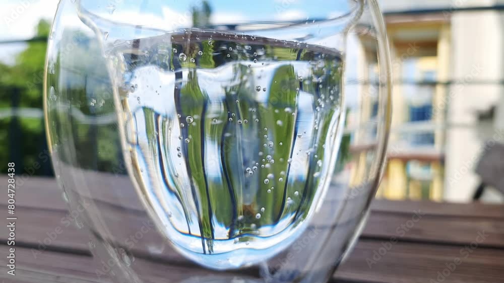 Glass of sparkling water on summer background. Double-walled glasse ...