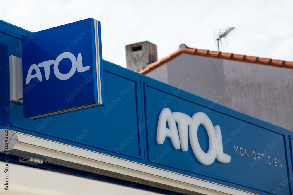 atol brand sign text and logo chain entrance front on wall facade optic ...