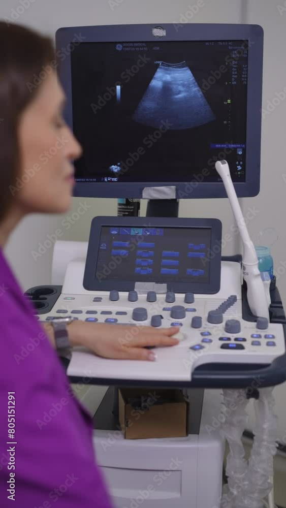 Vertical video. Female doctor performing an ultrasound scan. A woman ...