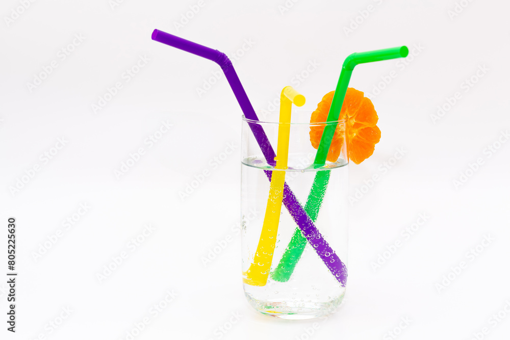 Colorful plastic straws and bubbles in a glass of fizzy drink on a ...