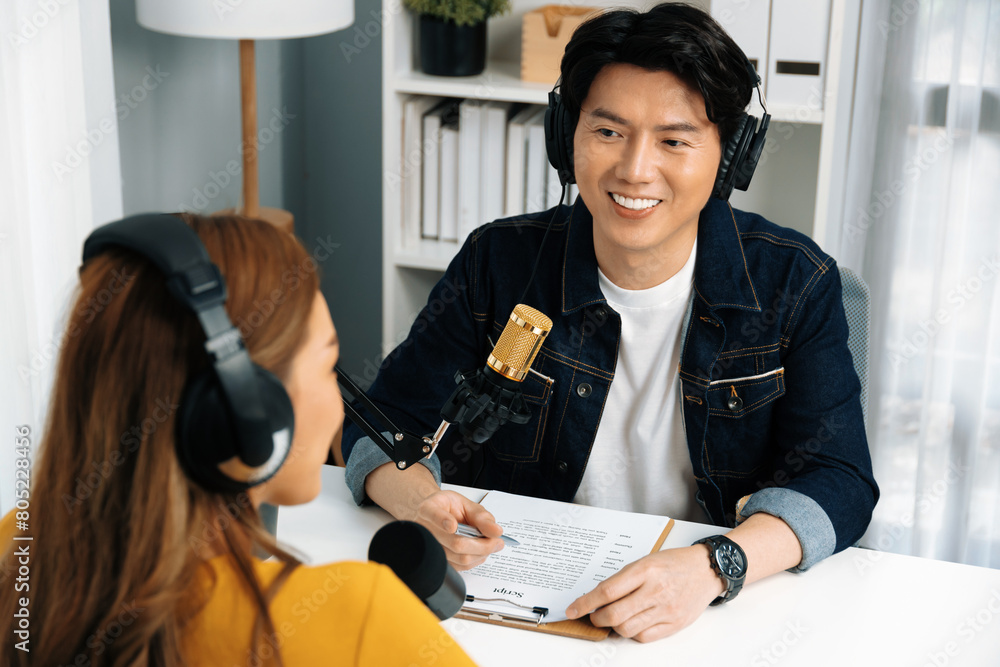 Smiling radio influencer host wearing headphone interviewing woman ...
