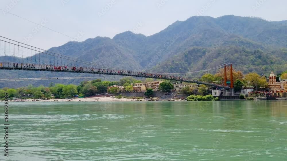 Locked shot showing the majestic suspension bridge Ram Lakshman jhula ...