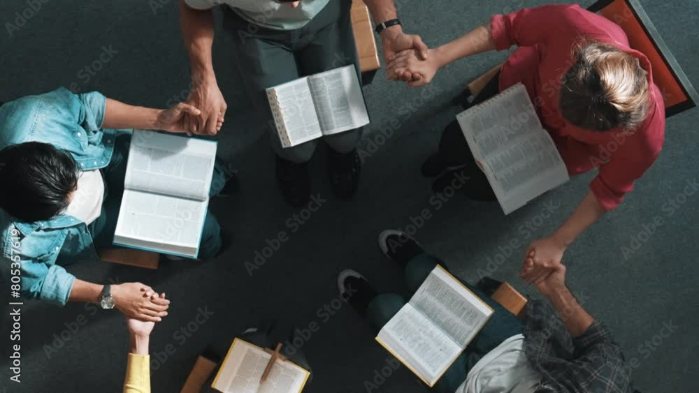 Top down view of diverse people holding hand and sitting in circle with ...
