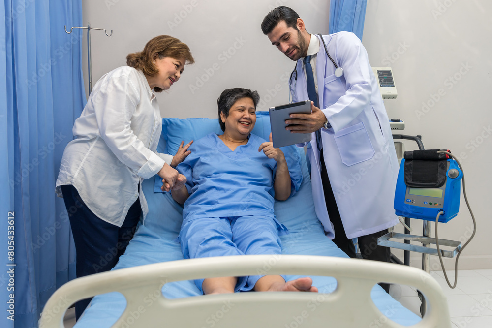 Doctor Visiting Patient On Ward. Hospitalized man lying in bed while ...