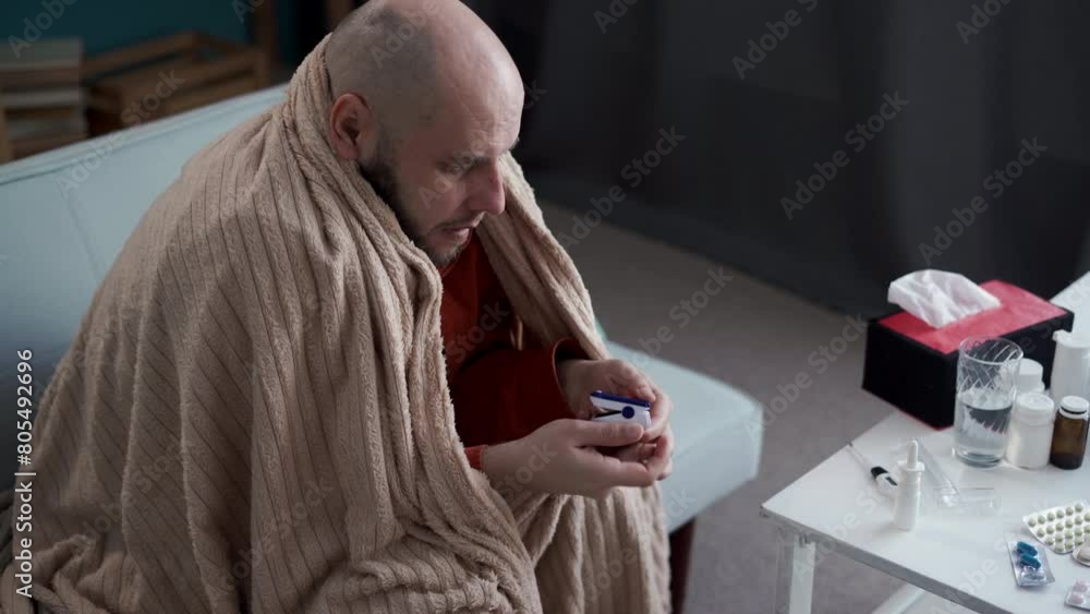 Sick man measures blood saturation with an electronic pulse oximeter ...