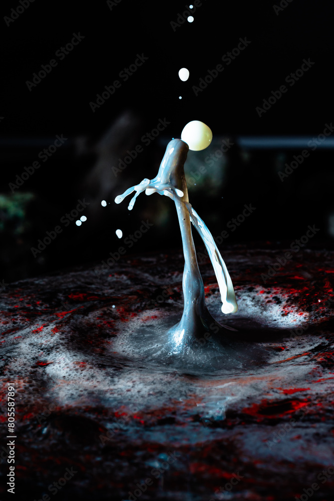 drops of colored water falling, colliding with each other forming ...