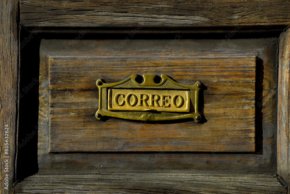 Old brass mailbox on wooden door, traditional way of delivering letters ...