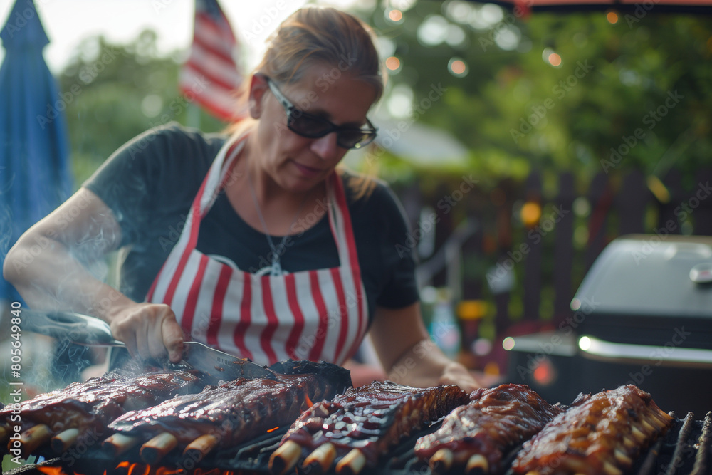 Woman cooking at a backyard barbecue for Independence Day, a culinary ...