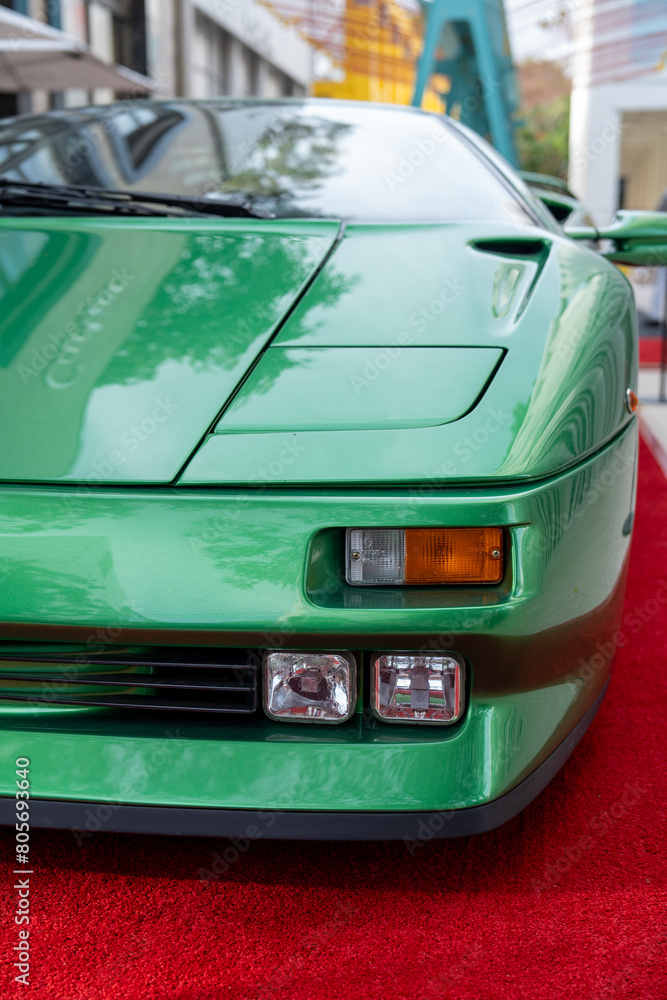 Headlights of bright sports car on low suspension presented at mechanic ...