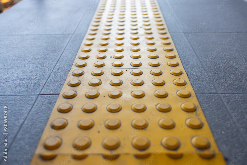 yellow tactile tiles are installed on outdoor pedestrian walkways to ...