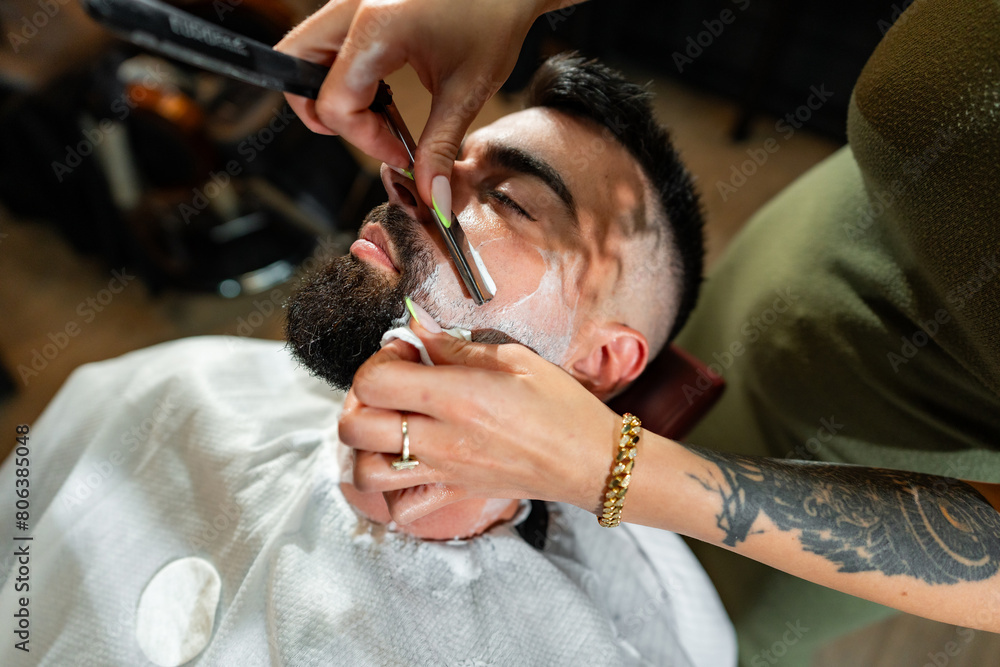 Precision and skill are shown as the barber meticulously shaves the ...