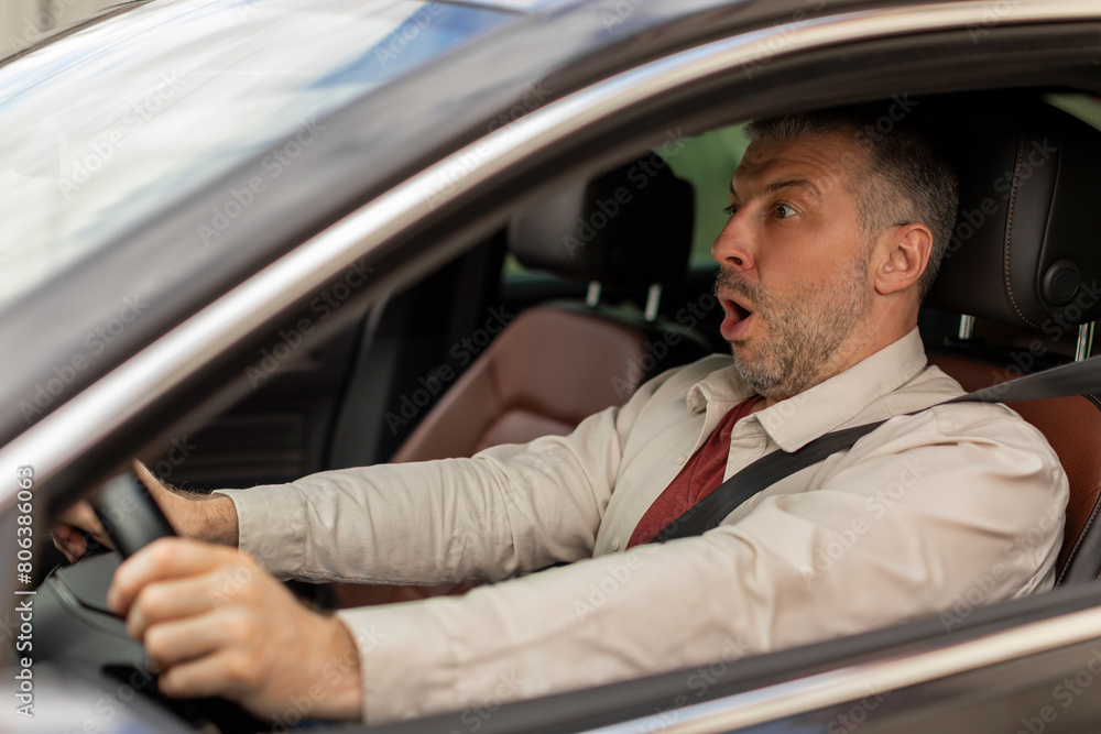 Stress of driving. Scared middle aged man holding steering wheel ...